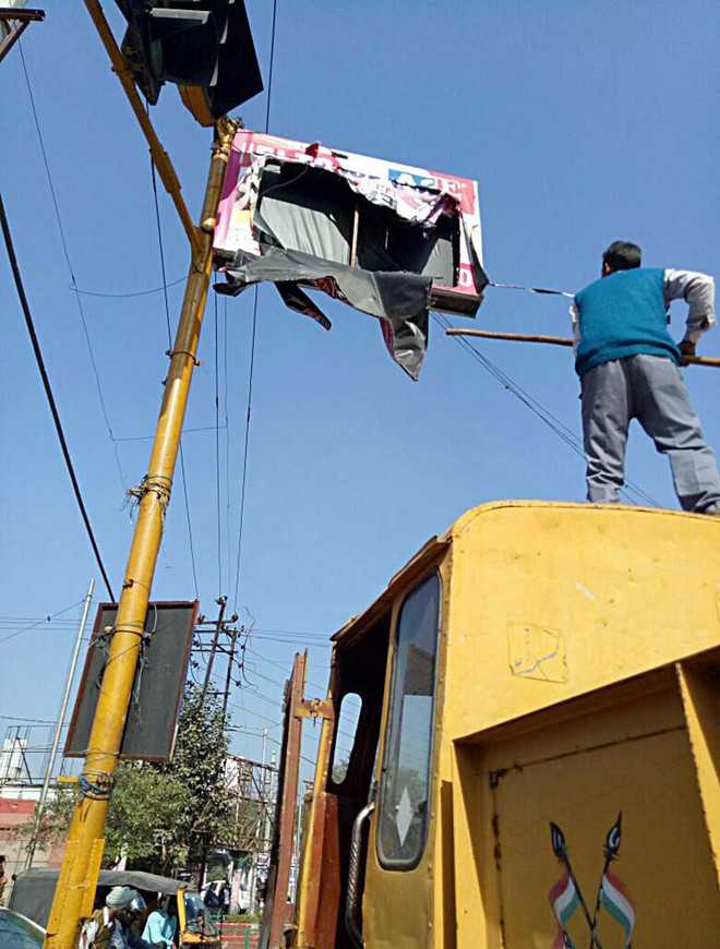 Illegal hoardings removed at traffic lights - The Tribune