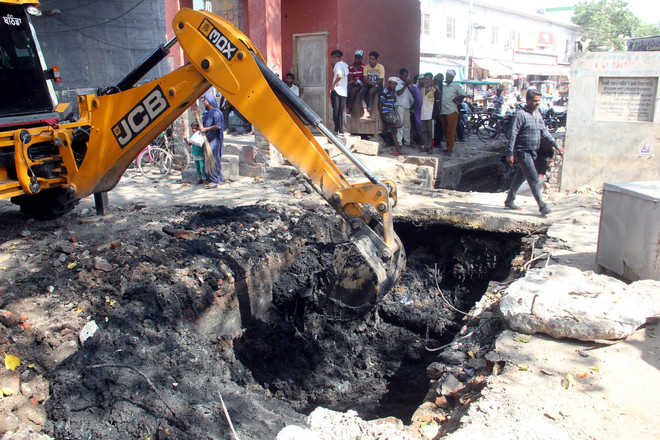 Congress workers carry out cleaning work of open drain - The Tribune