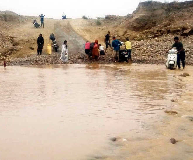 No bridge, commuters risk lives crossing flooded river : The Tribune India